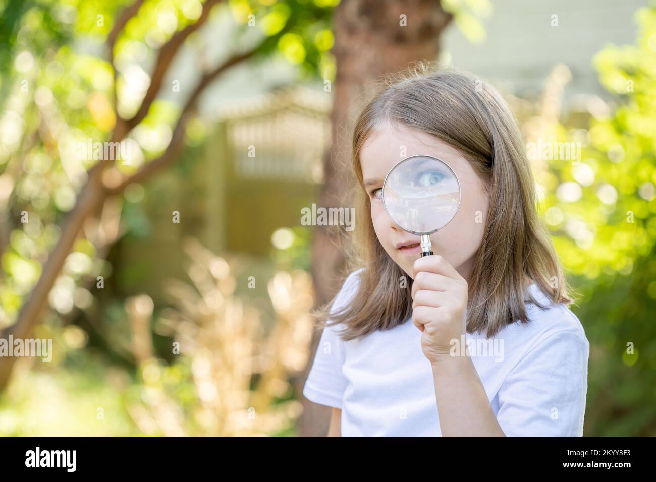 Neugieriges, cleveres Kind im Grundschulalter, Mädchen, das durch eine ...