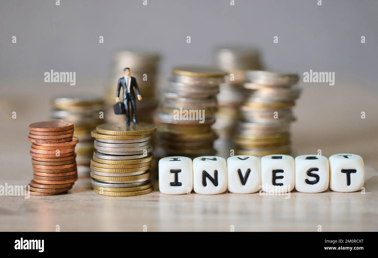 Investieren Sie Botschaften und Geschäftsleute, die auf einer Münze auf ...