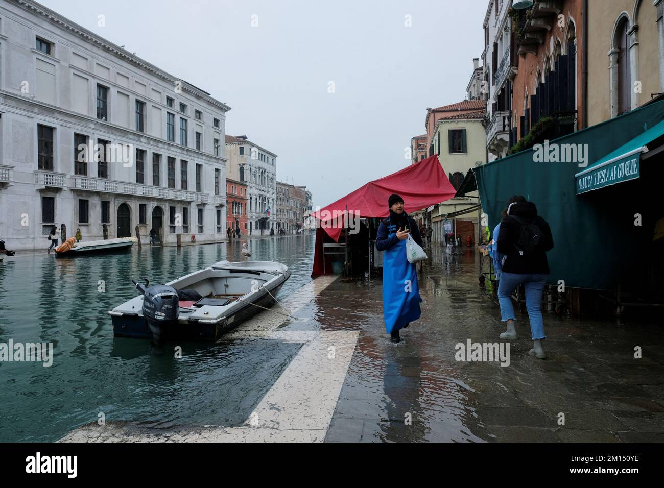 In Venedig, Italien, waten die Menschen in einer überfluteten Straße ...