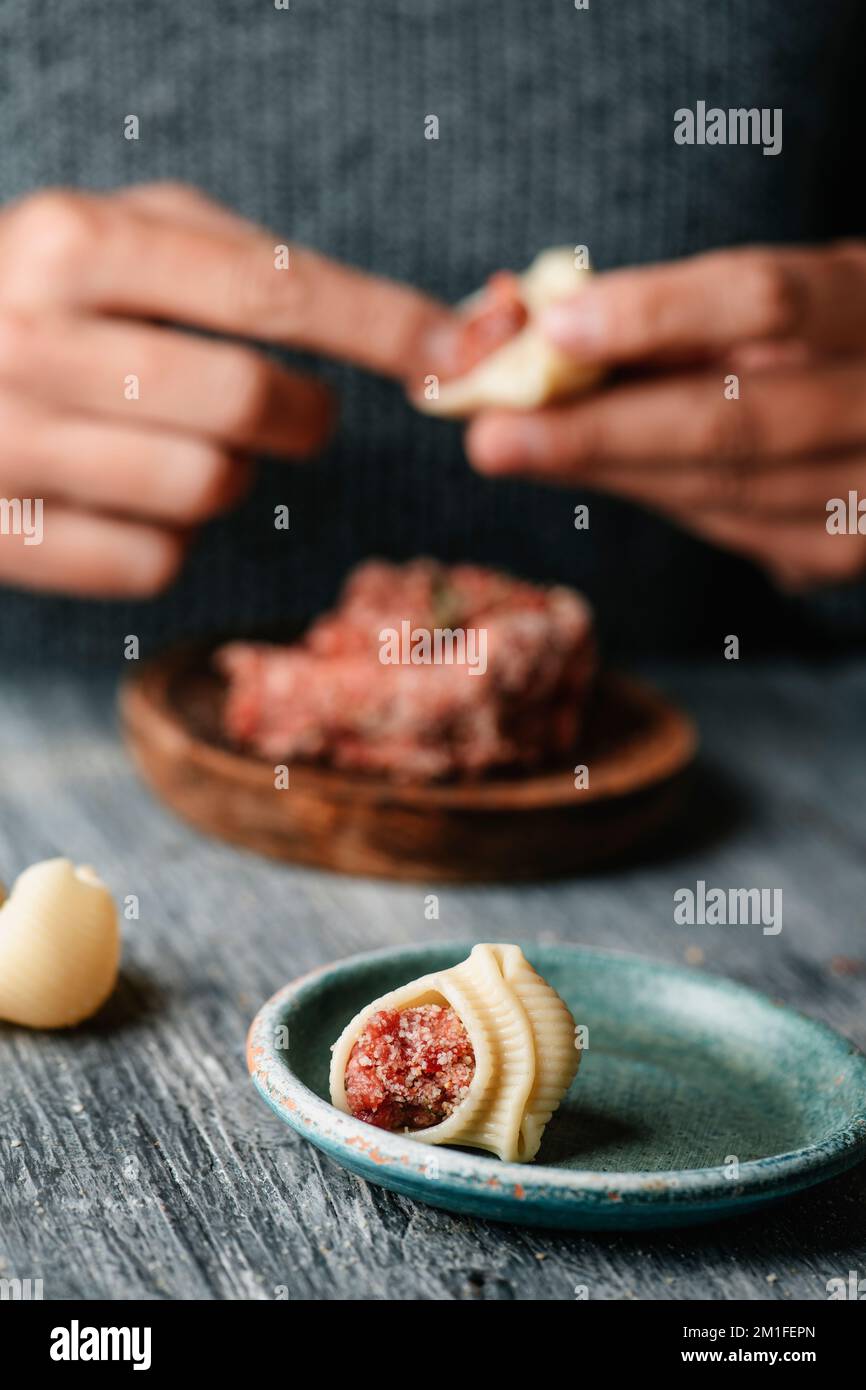 Ein Mann füllt Galets Pasta mit Hackfleisch, um sopa de Galets oder ...