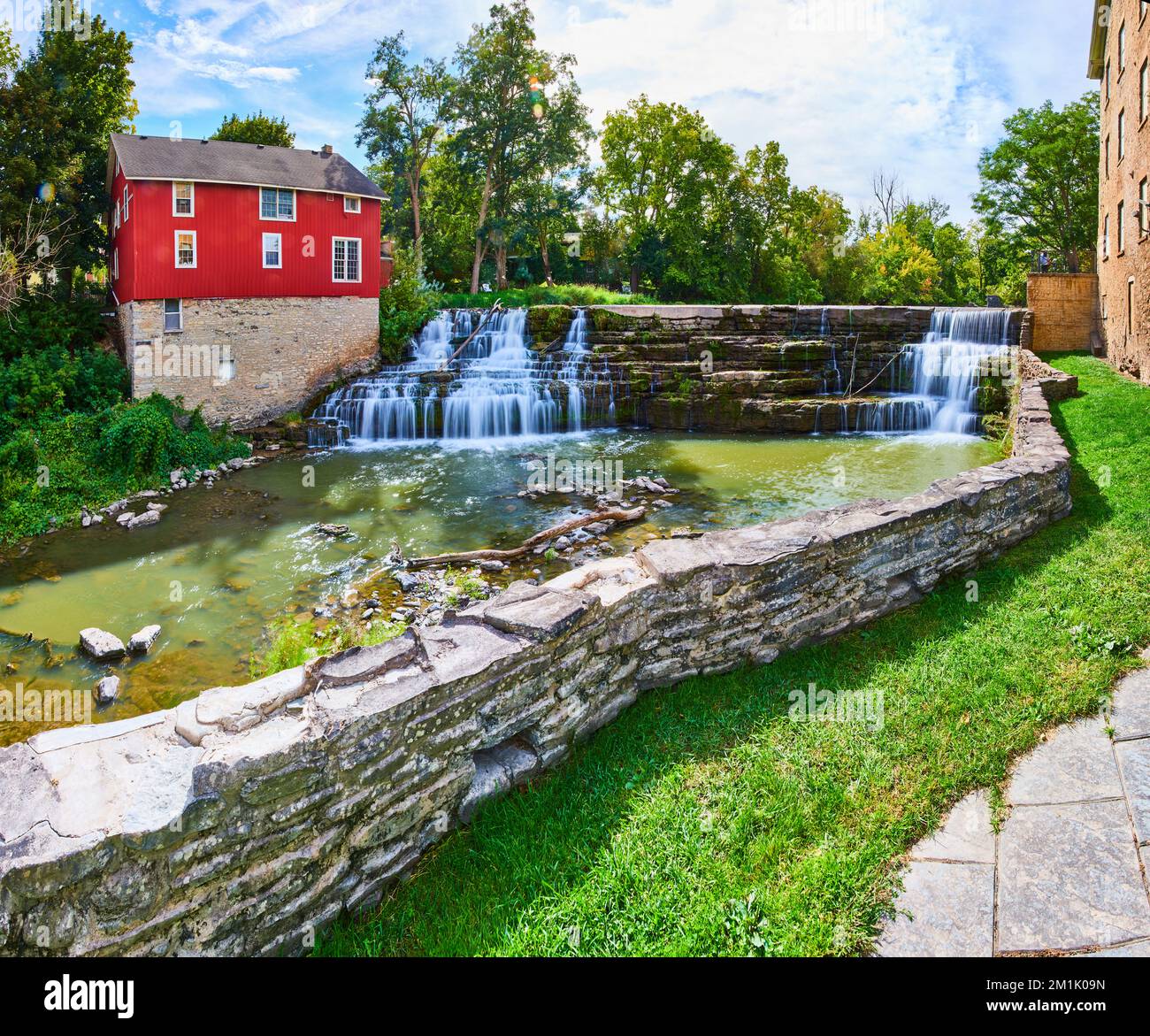 Fluss mit Wasserfall in der Stadt neben einer wunderschönen roten ...