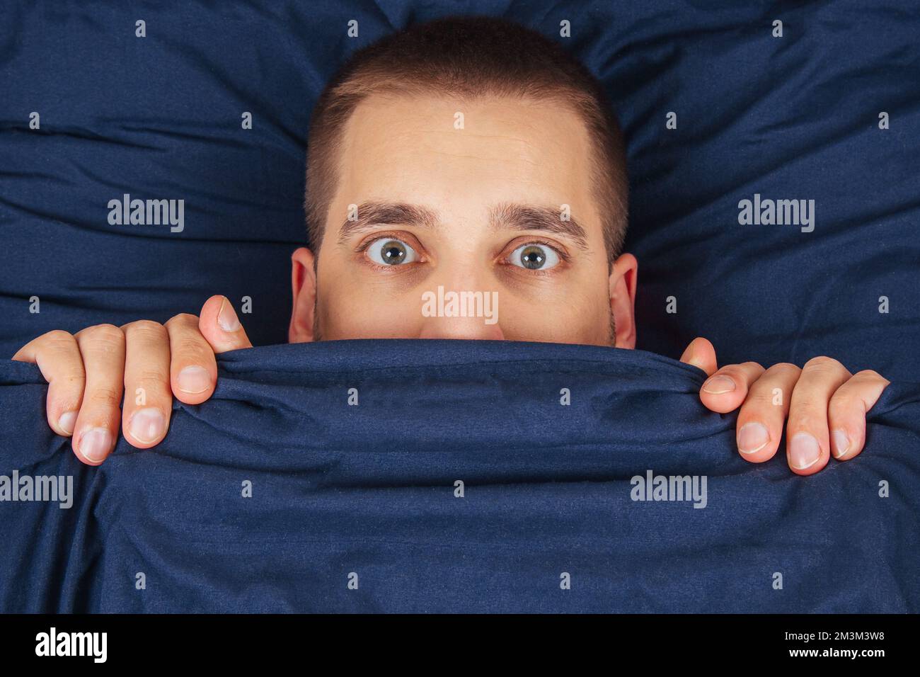 Direkt in den Rahmen schauen. Ein hübscher junger Mann, der sich hinter ... Direkt in den Rahmen schauen. Ein hübscher junger Mann, der sich hinter ...