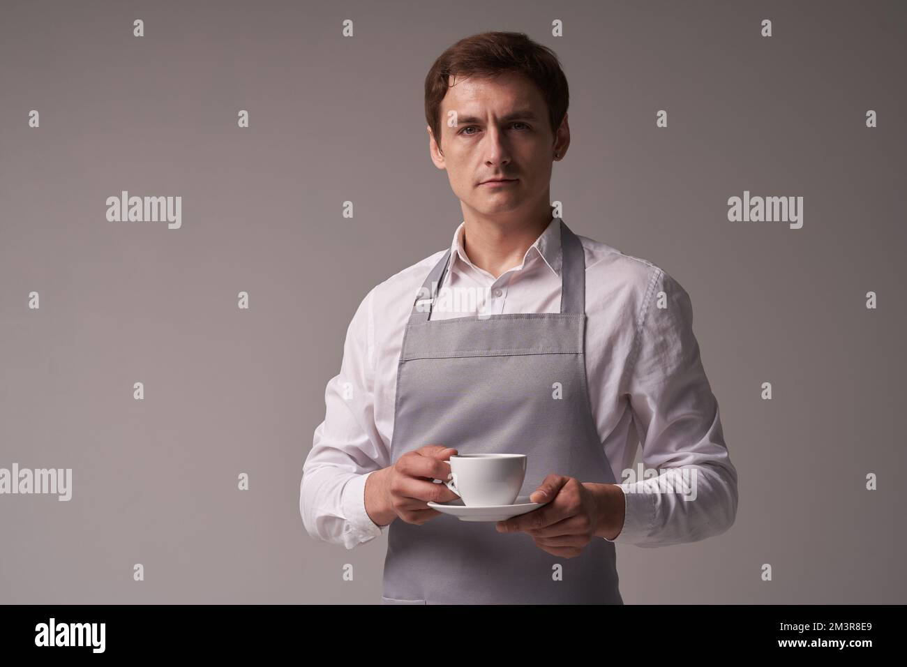 Ein positiver männlicher Kellner schaut direkt in die Kamera. Der ...