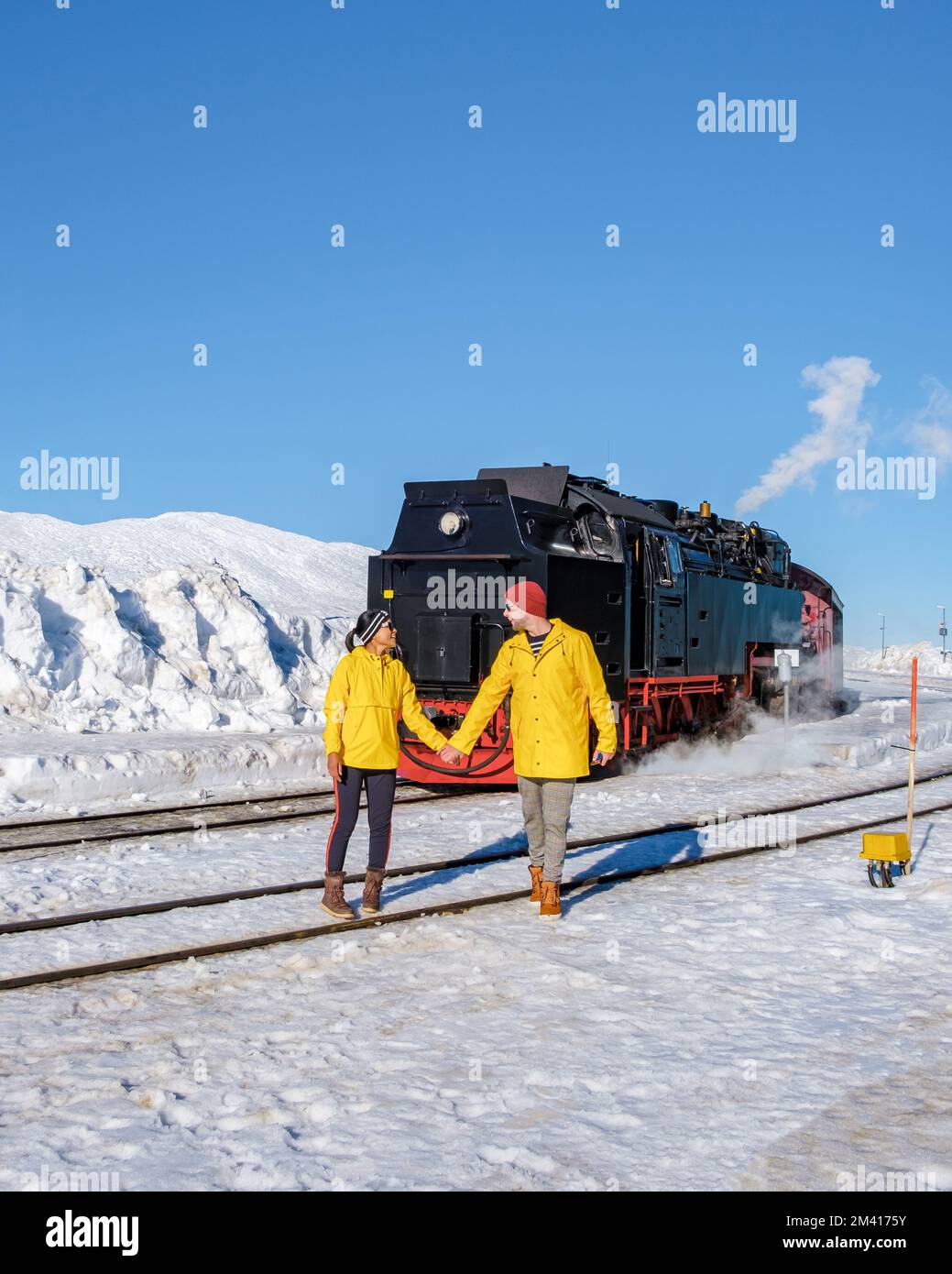 Ein paar Männer und Frauen, die im Winter im Schnee vor einer ...