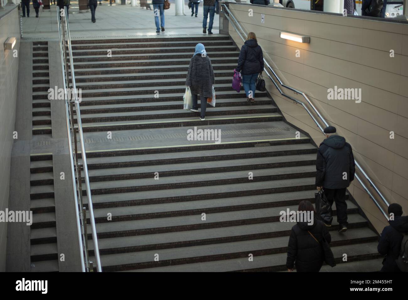 Die Leute gehen die Treppe hinauf. Verlassen Sie die U-Bahn. Die Passagiere gehen von der U-Bahn ...
