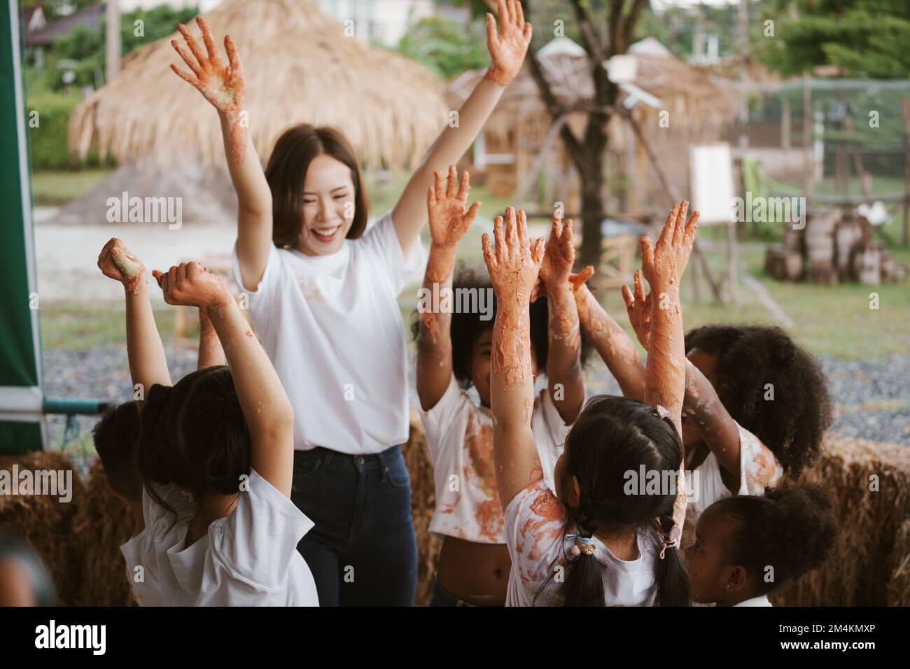 Eine Gruppe von Kindern spielt bunte Wasserfarben und Farbflecken auf ...