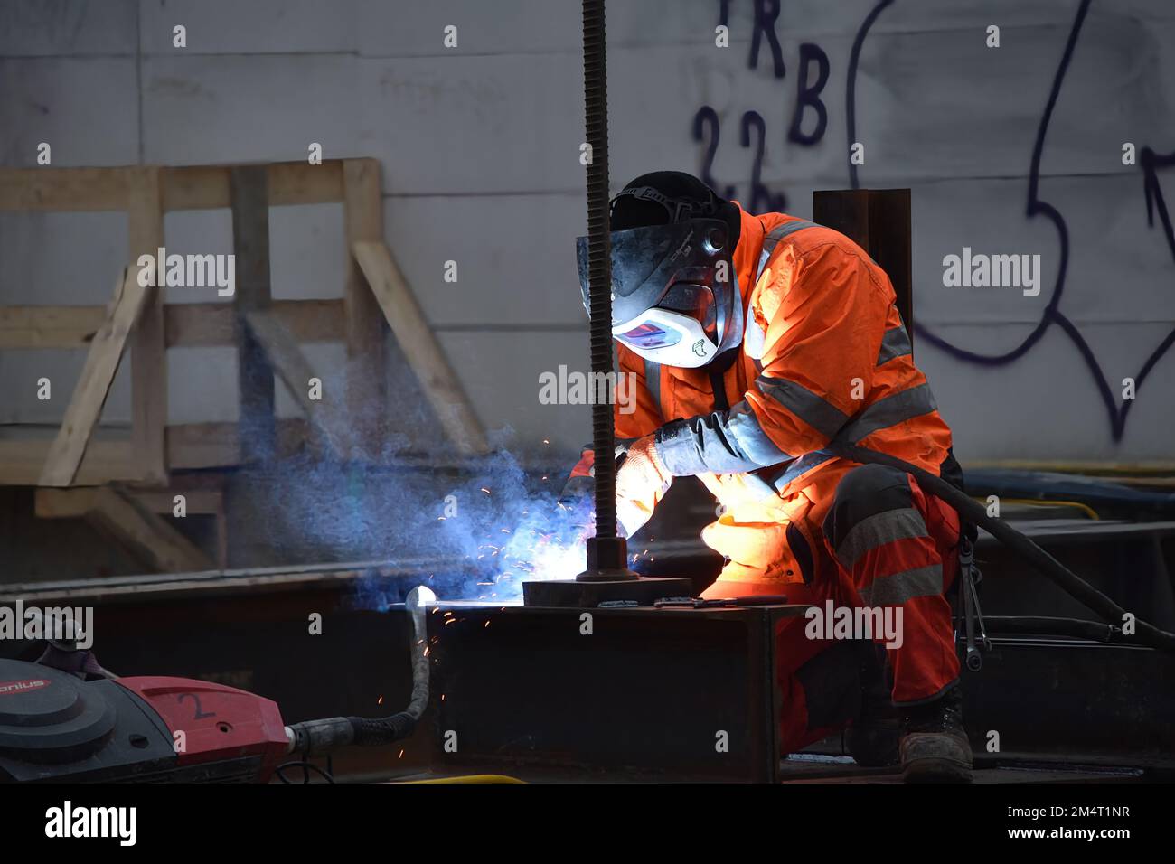 Ein Mann im Arbeitsanzug und mit Helm, Schweißarbeiten auf der ...