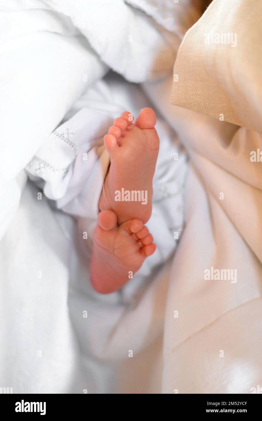 Das Sakrament der Taufe eines Babys in der Kirche, die Beine des Babys ...