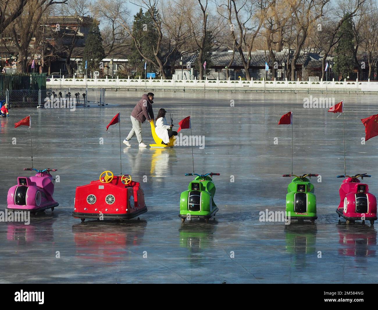 PEKING, CHINA - 27. DEZEMBER 2022 - Besucher spielen auf dem Eis auf ...