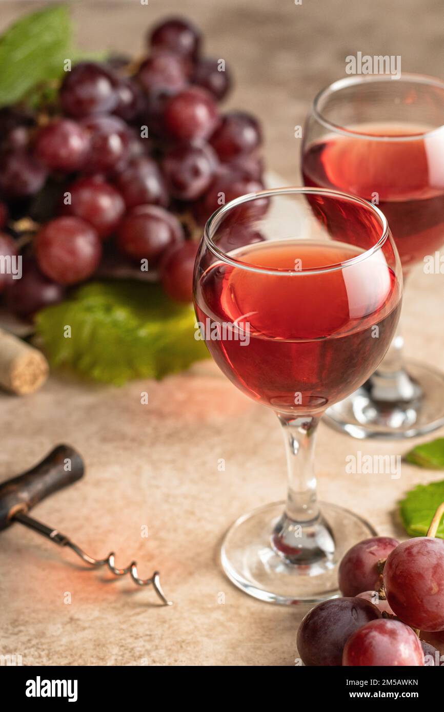 Zwei Gläser Rotwein, ein Haufen rote Trauben und Korkenzieher auf ...