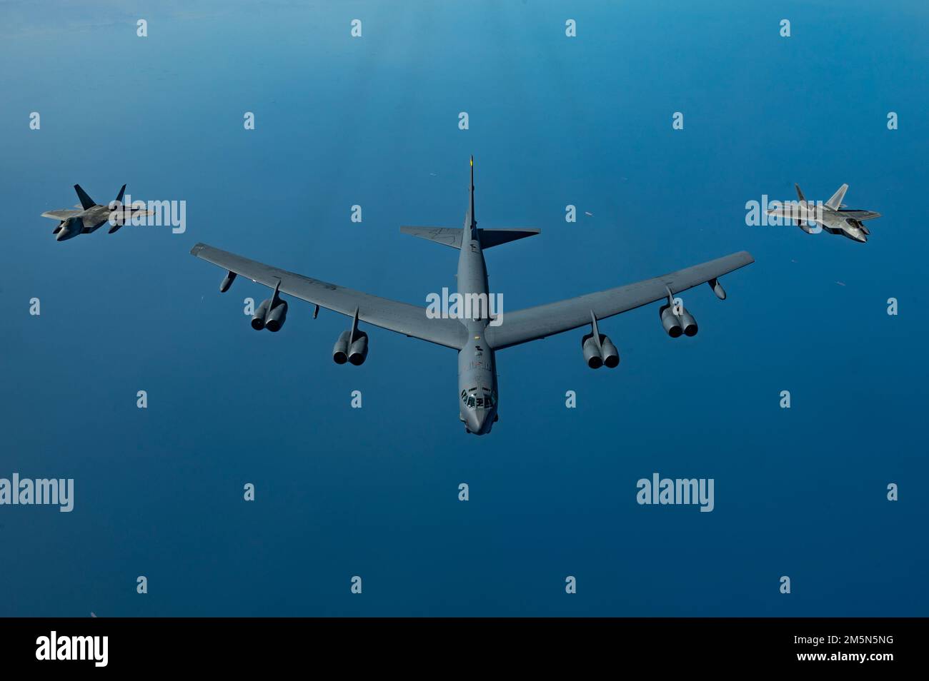 USA Air Force F-22 Raptors fliegen neben einem US-amerikanischen Air Force B-52H Stratofestung ...