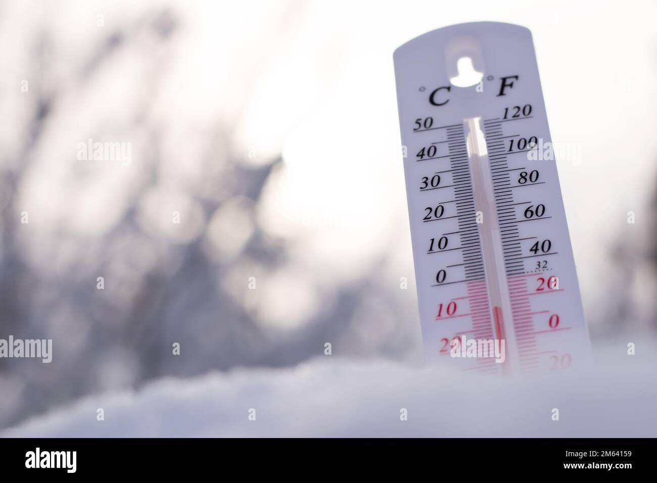 Das Thermometer liegt im Winter auf dem Schnee und zeigt eine negative ...