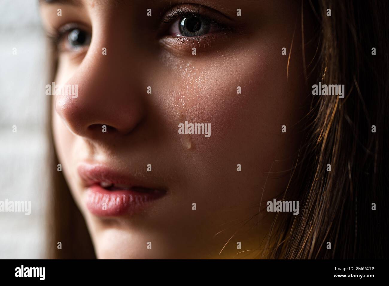 Ein Kind weint mit einer Träne auf der Wange. Nahaufnahme Kind weinend ...