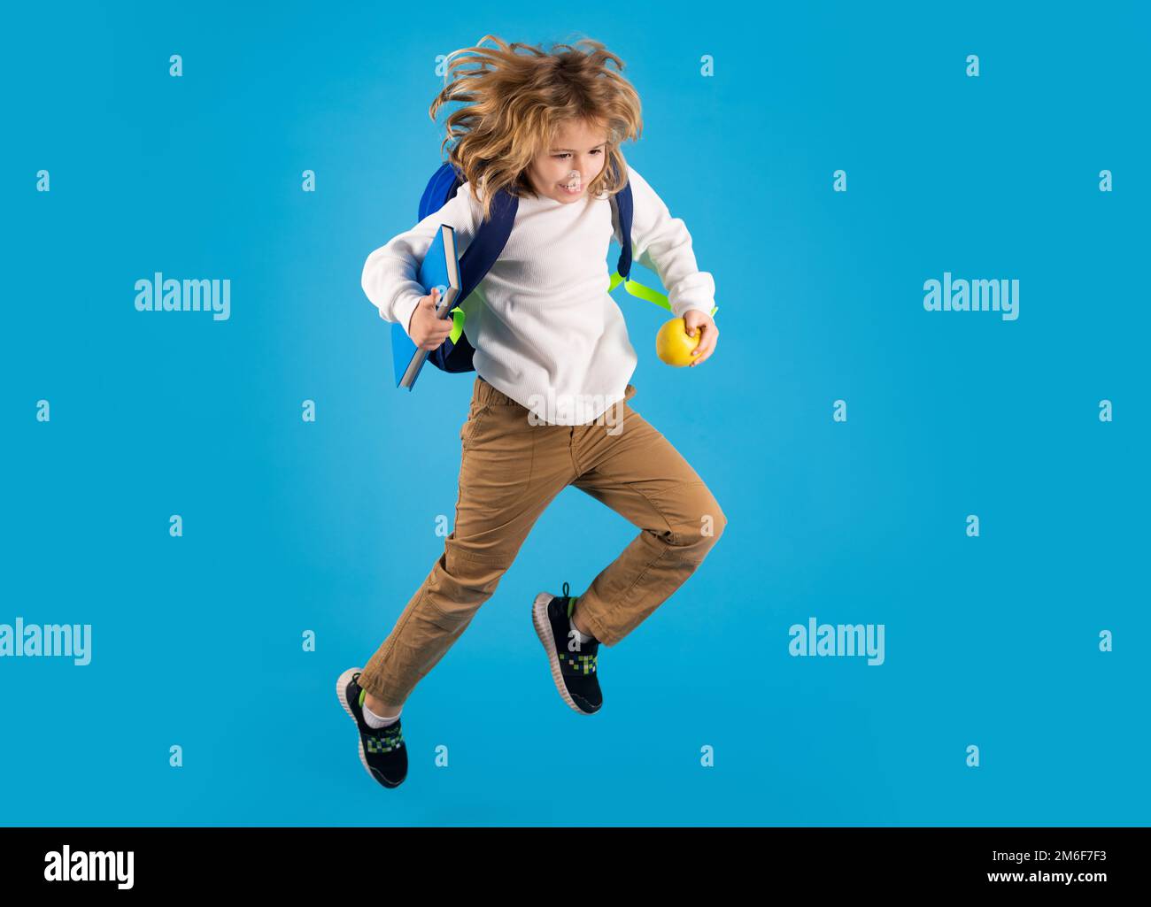 Kind springt und genießt die Schule. Voller Körper eines ...