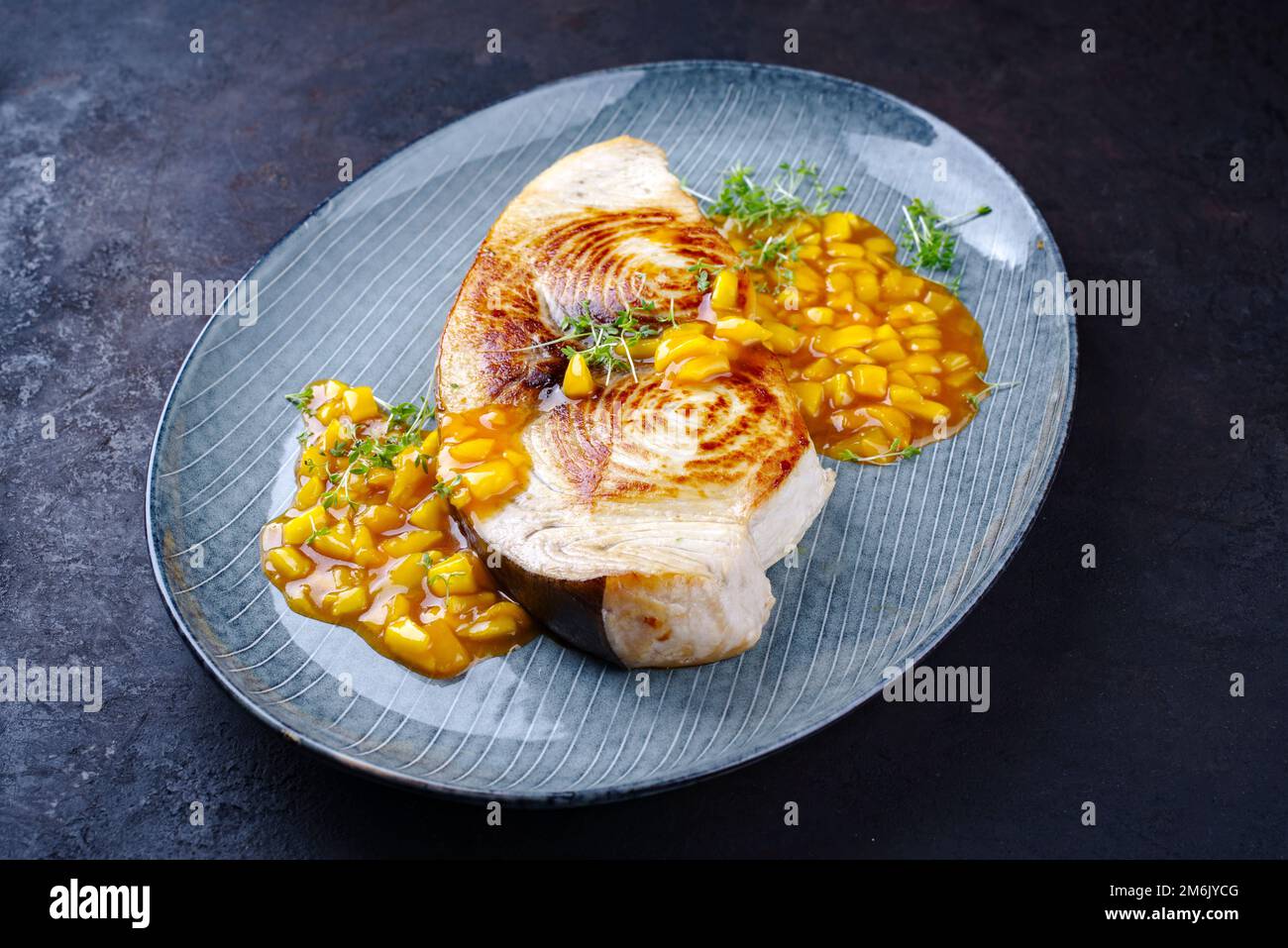 Gebratenes Schwertfischsteak mit Mango-Chutney und Kräutern, serviert ...