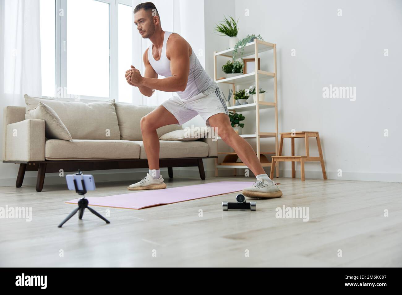 Mannsport, ein Workout-Band auf seinem Handy und wiederholte Übungen ...