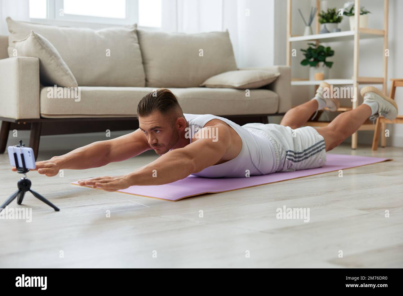 Mannsport, ein Workout-Band auf seinem Handy und wiederholte Übungen ...