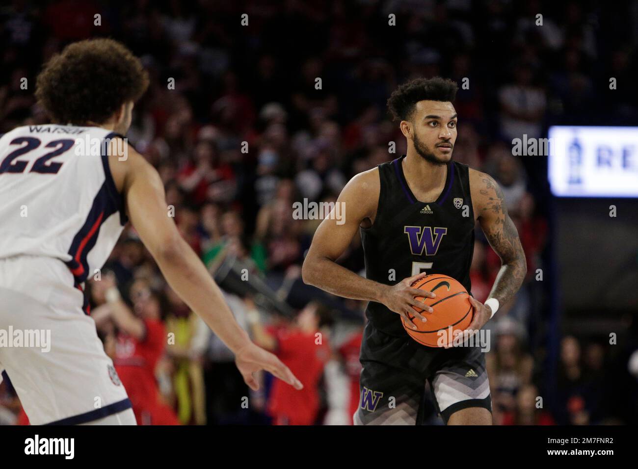 Washington guard Jamal Bey, right, controls the ball while defended by ...
