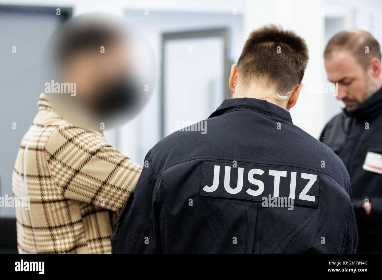 10. Januar 2023, Sachsen, Dresden: Ein Angeklagter (l) wird von Gerichtsbediensteten in ...