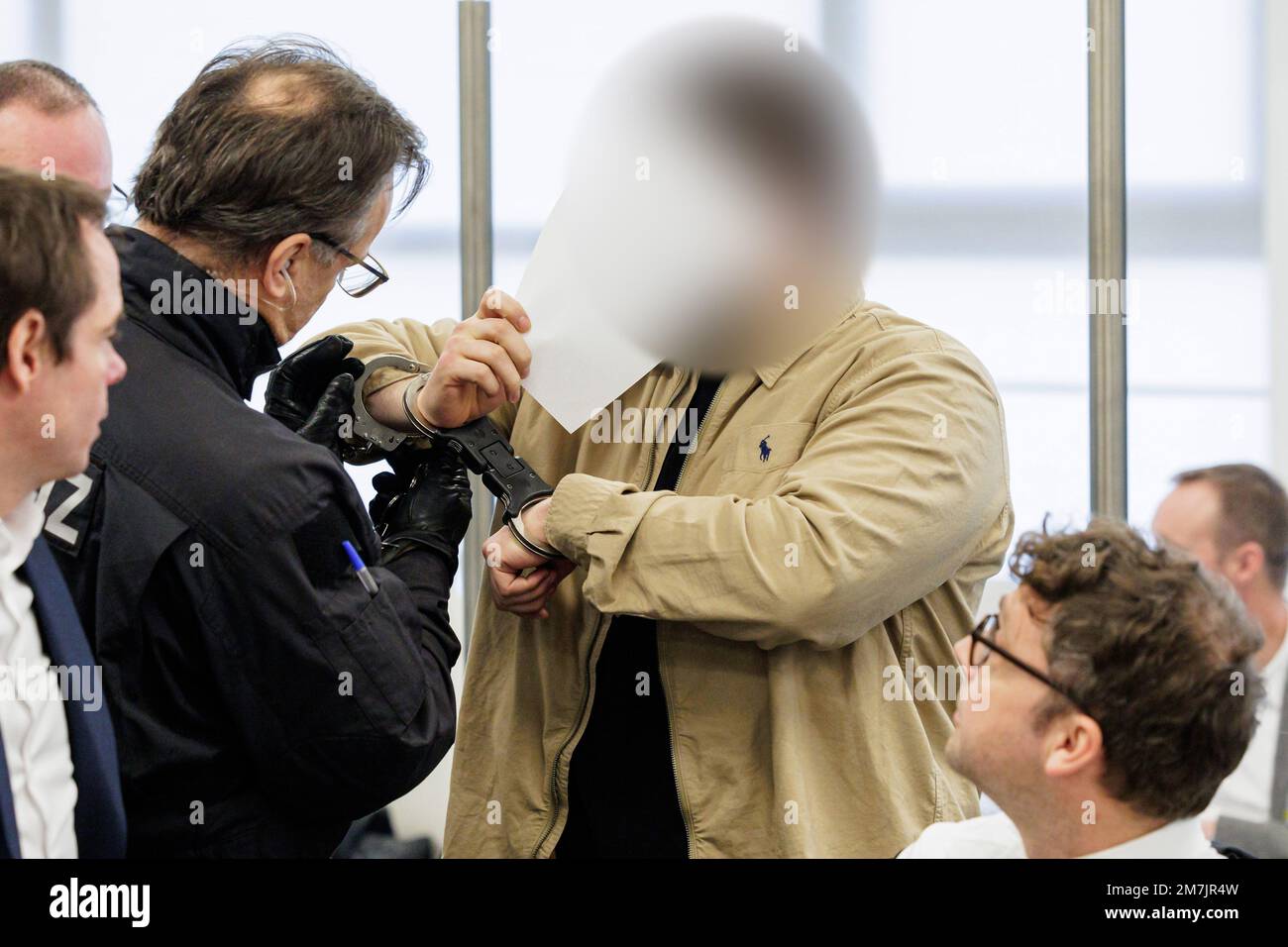 10. Januar 2023, Sachsen, Dresden: Ein Angeklagter (M) wird von Gerichtsbediensteten in ...