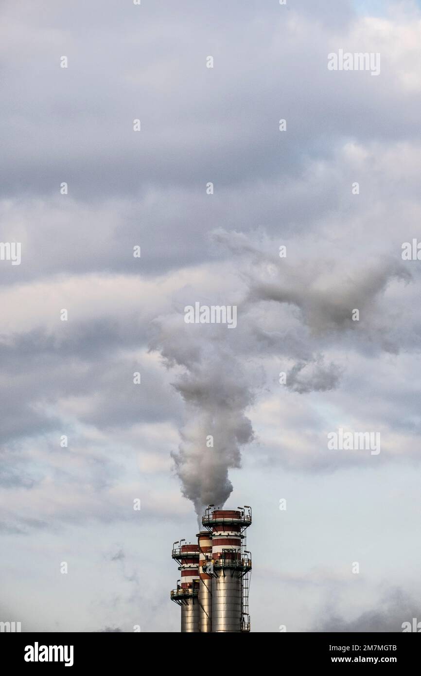 Schornstein, der Rauch in einer Raffinerie ausatmet, mit dem Himmel im ...