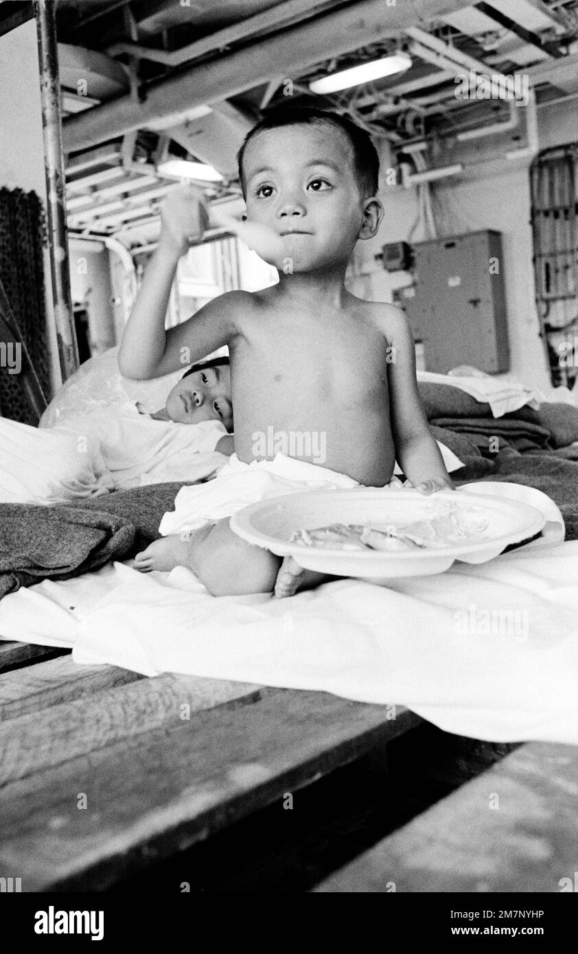 Ein vietnamesisches Kind isst, nachdem es vom Kriegsschiff USS SAN JOSE ...