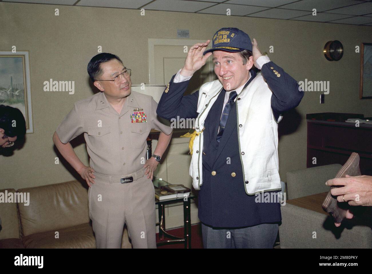 Der Marinesekretär John F. Lehman Jr. probiert eine Schiffskappe ...