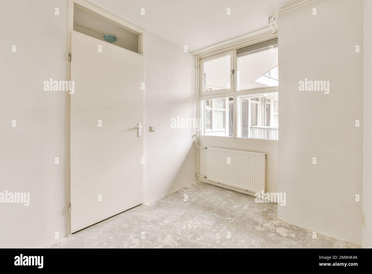 Ein leerer Raum mit weißen Wänden und Bodenbrettern an der Wand, es ...