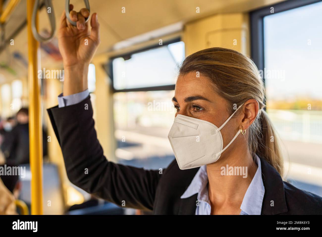 Geschäftsfrau trägt chirurgische FFP2 Maske Gesicht, um sich selbst zu ...