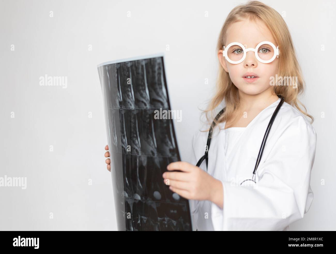 Ein schweres, weißes Kind, ein kleiner Arzt mit Spielzeugbrille und ...