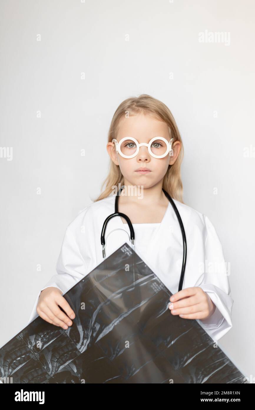 Kaukasisches Kind in Arztuniform mit Brille und Stethoskop, das traurig ...