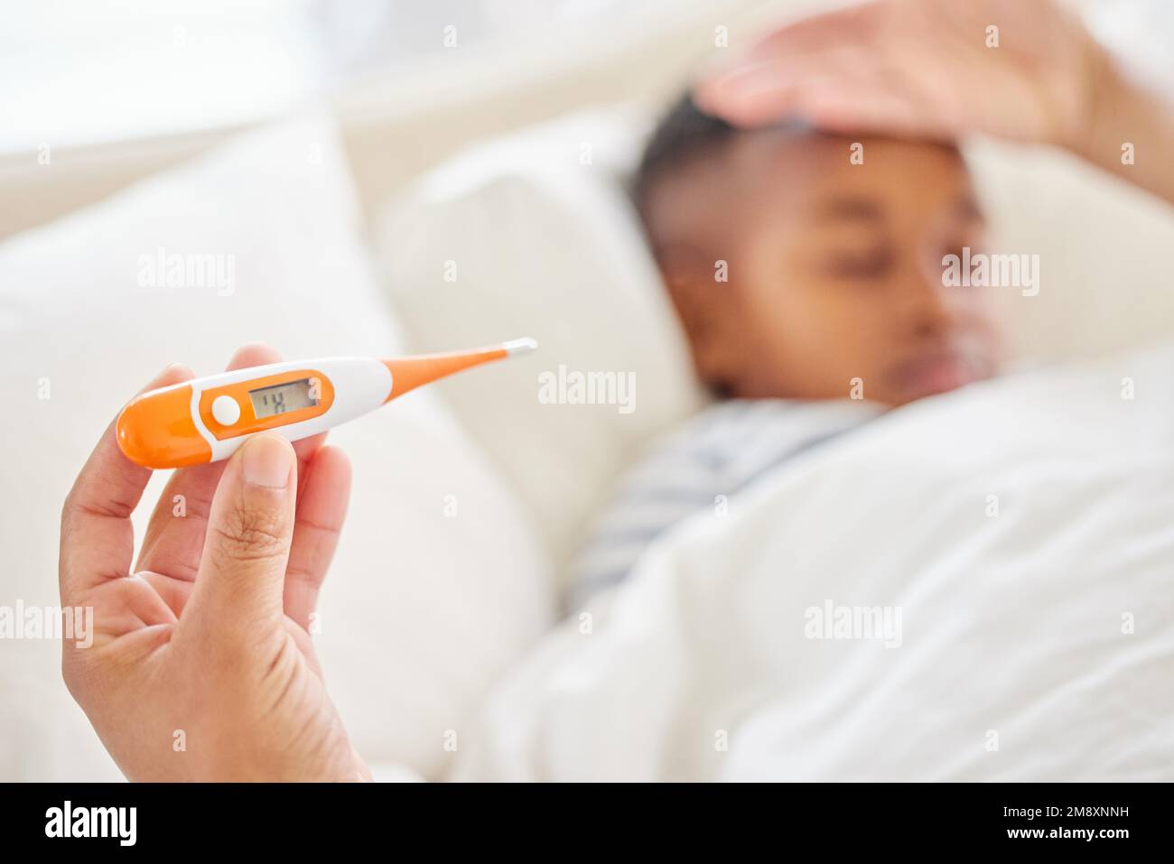 Jemand hat Fieber. Eine nicht erkennbare Mutter, die ein Thermometer ...