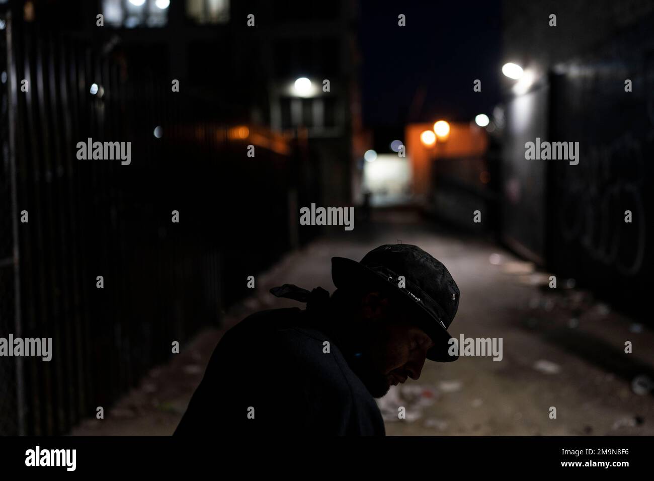 A homeless addict falls asleep standing up in an alley after smoking ...