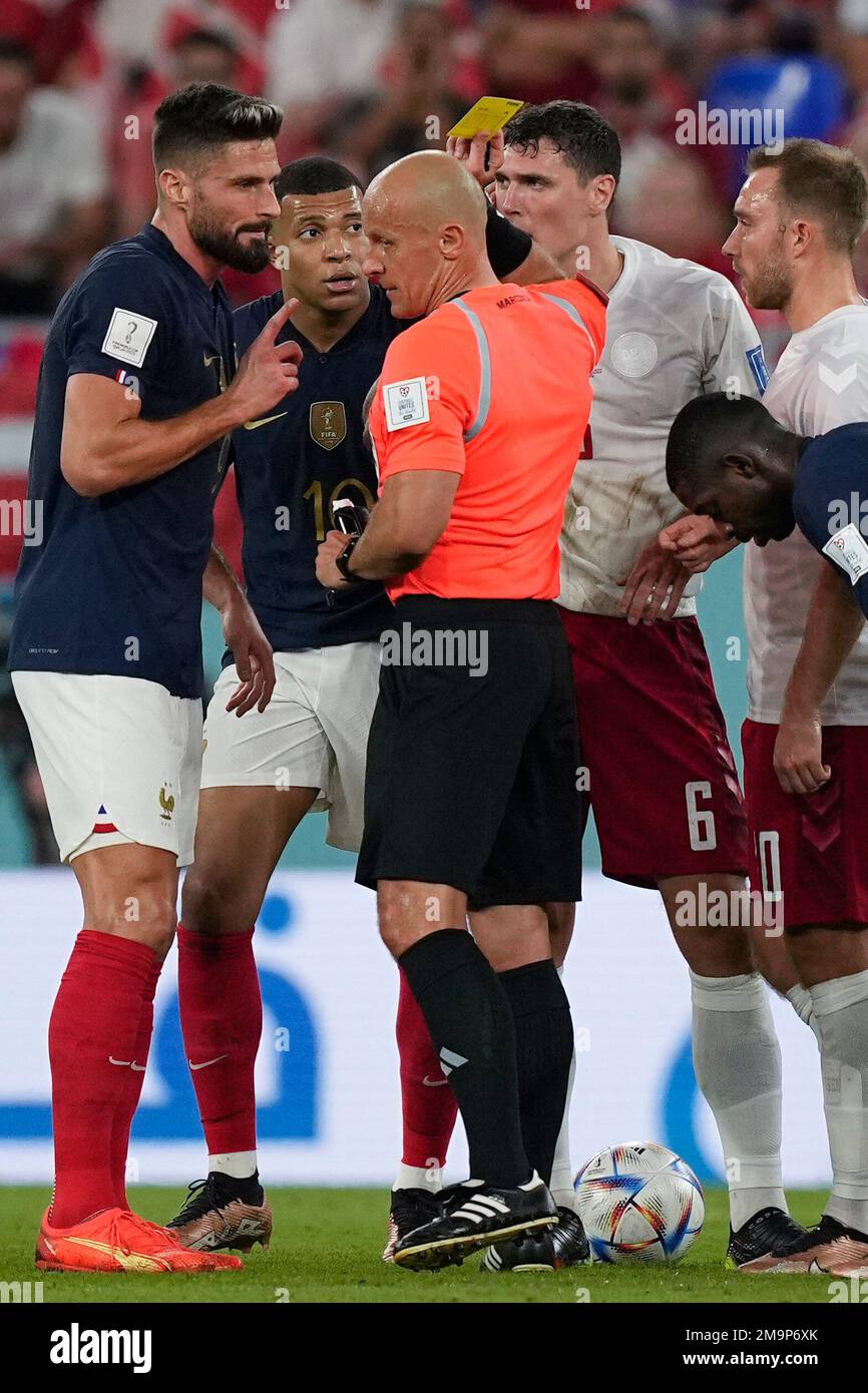 Referee Szymon Marciniak, of Poland, shows the yellow card to Denmark's ...