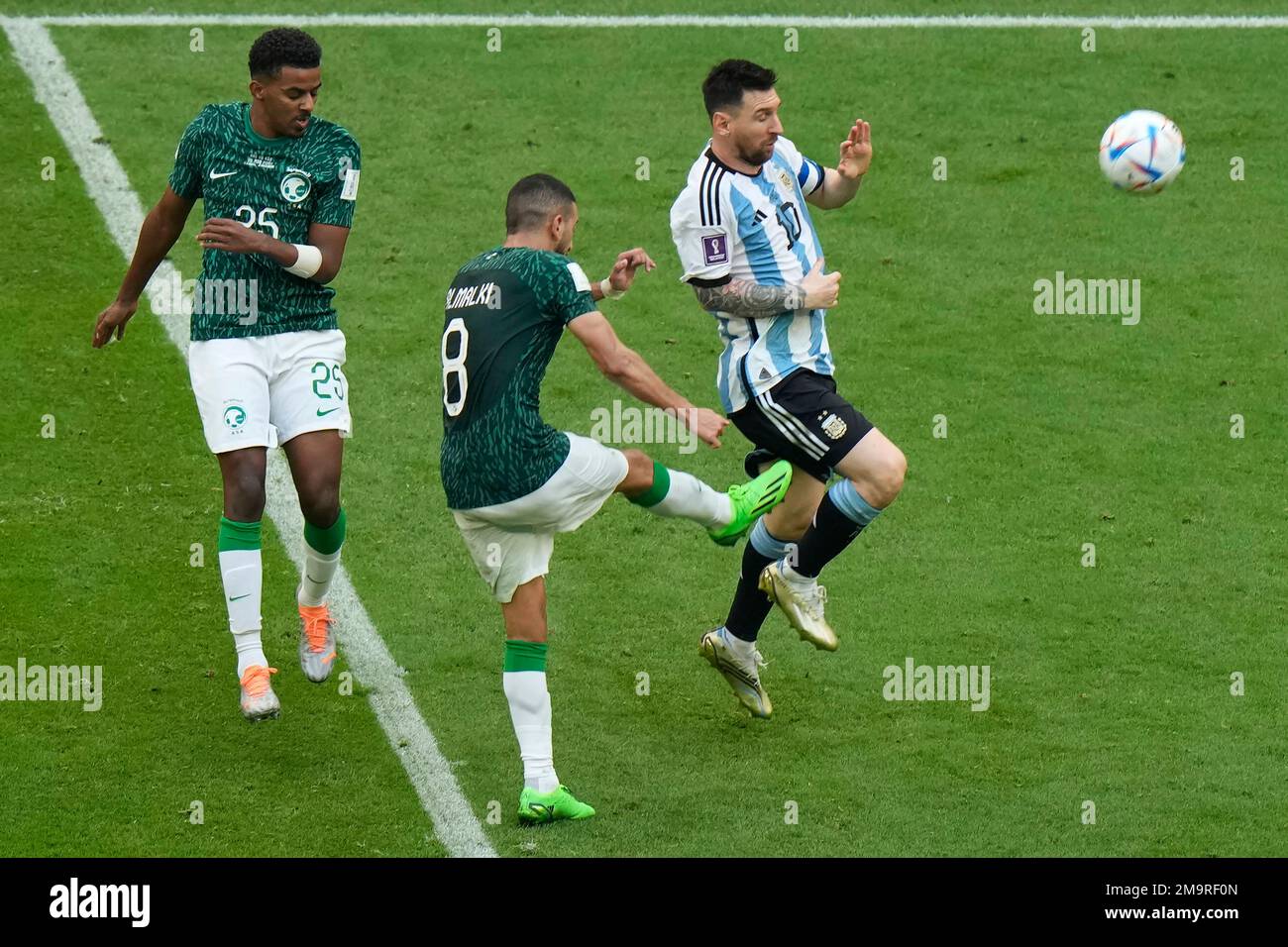 Saudi Arabia's Abdulelha Al-Malki, center, kicks the ball past ...