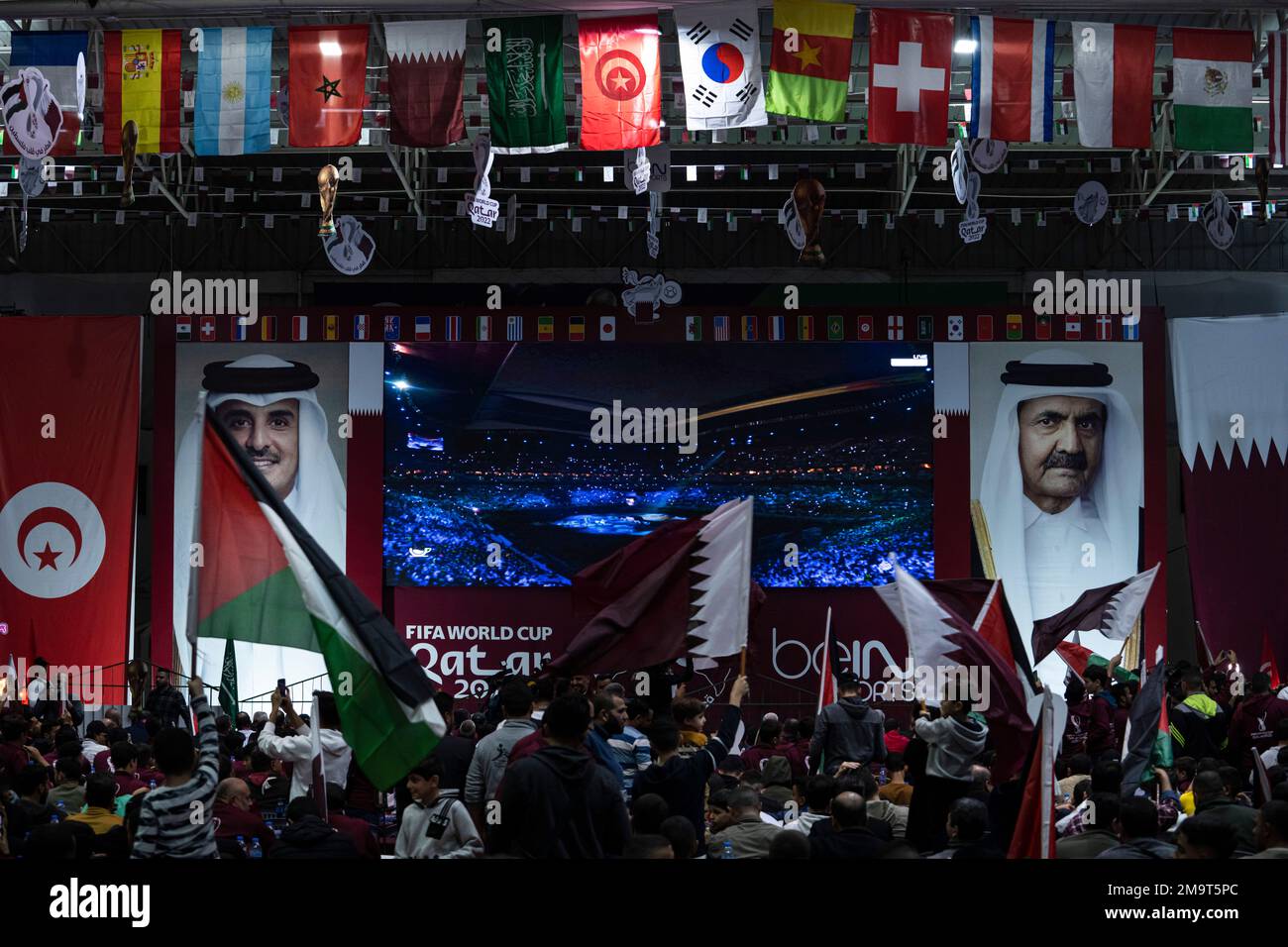 Palestinian soccer fans watch a live broadcast of the 2022 World Cup opening match between Qatar ...