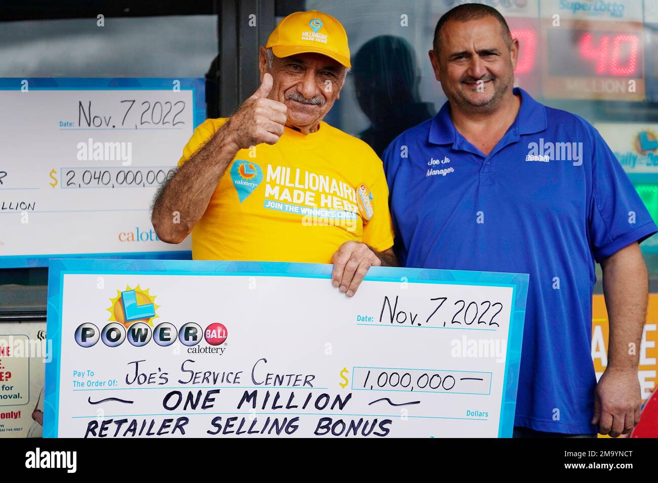 Business owner Joe Chahayed holds a check with his son, Joe Chahayed ...