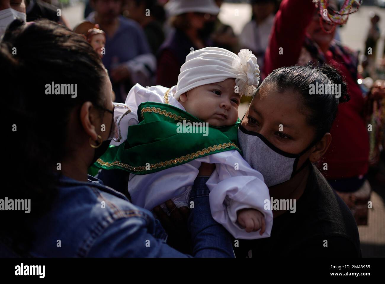 A woman carries a baby dressed as Saint Jude, also known as Judas and ...
