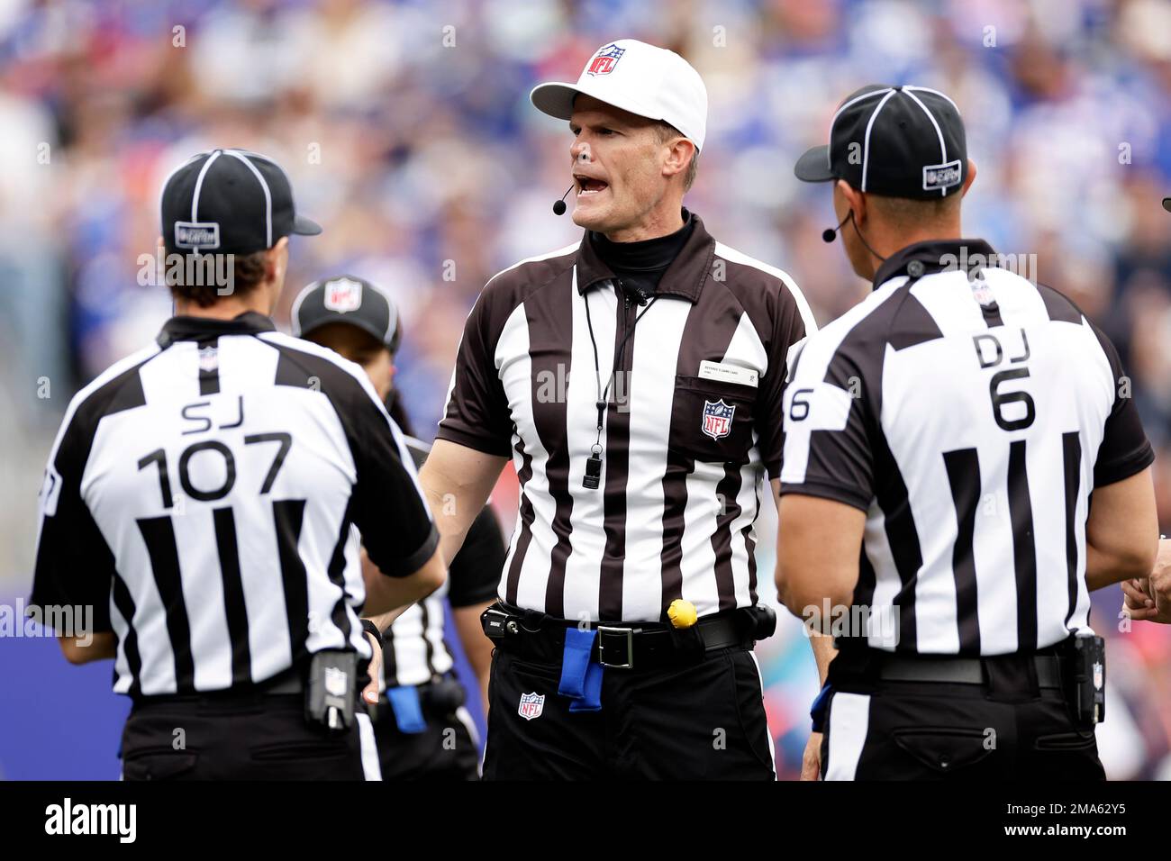 Referee Clay Martin (19) talks with side judge Dave Hawkshaw (107) and ...