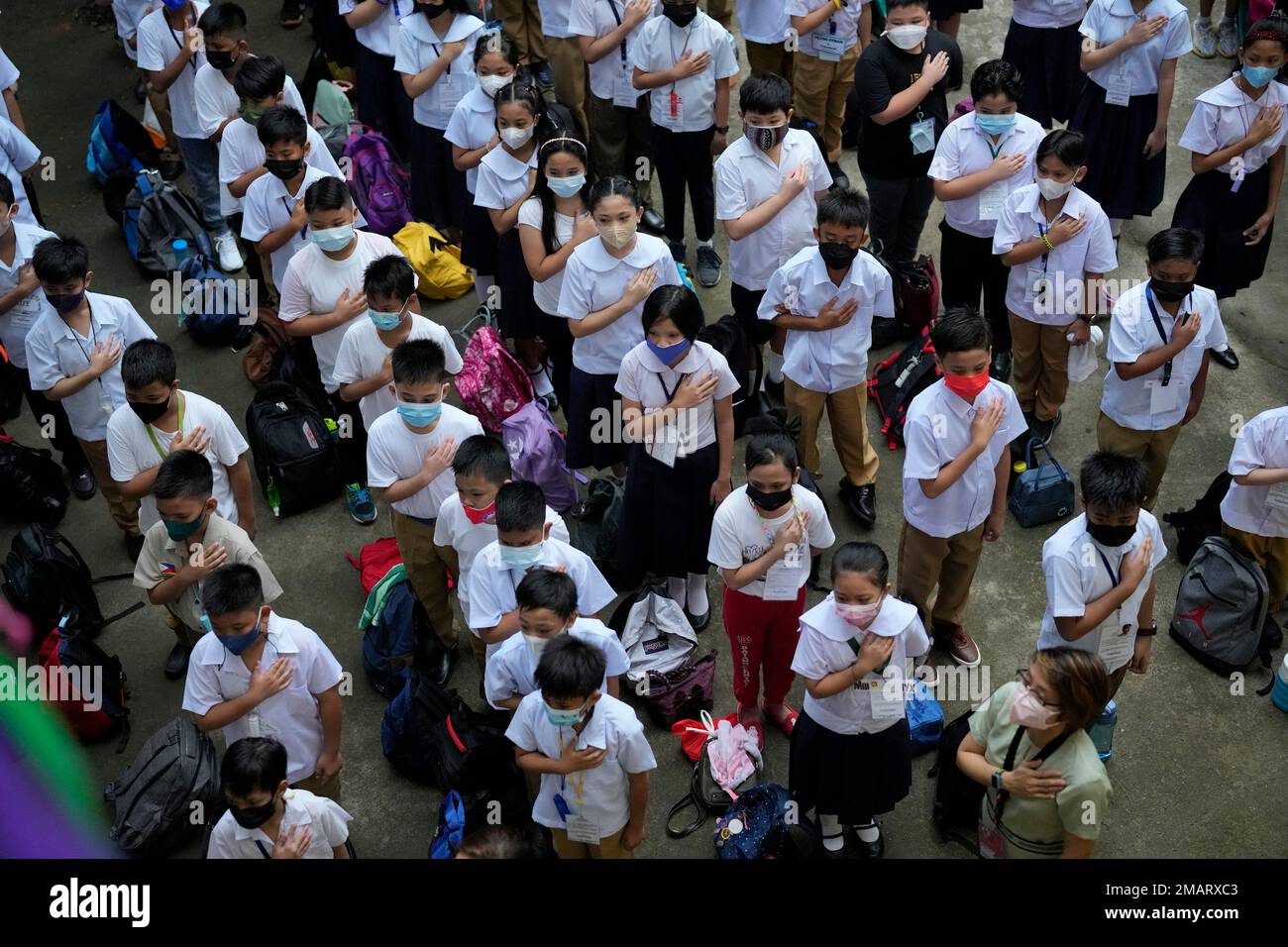 Students attend a flag raising ceremony during the opening of classes ...