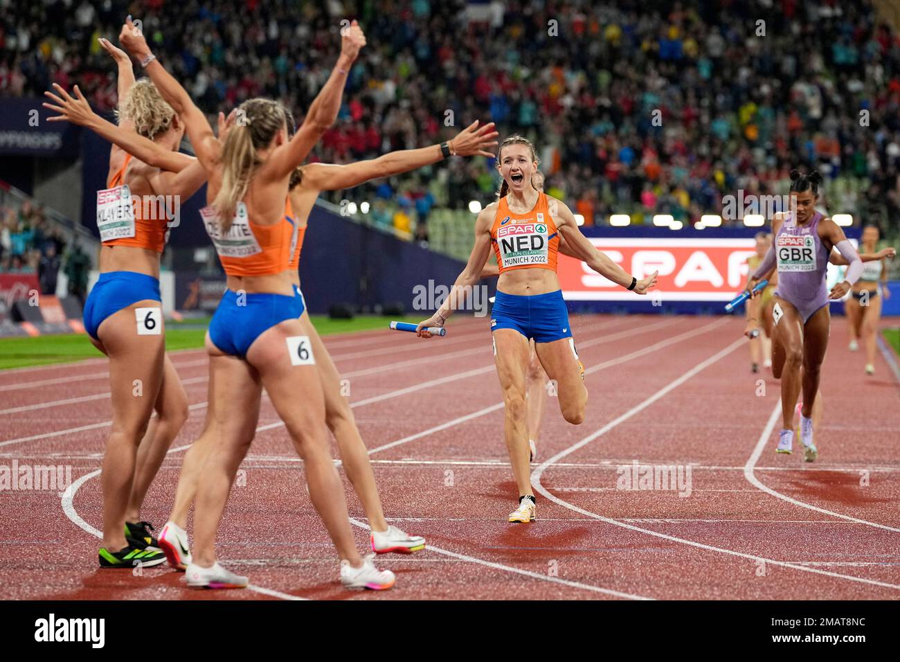 Femke Bol, of the Netherlands, center, celebrates with her team after ...