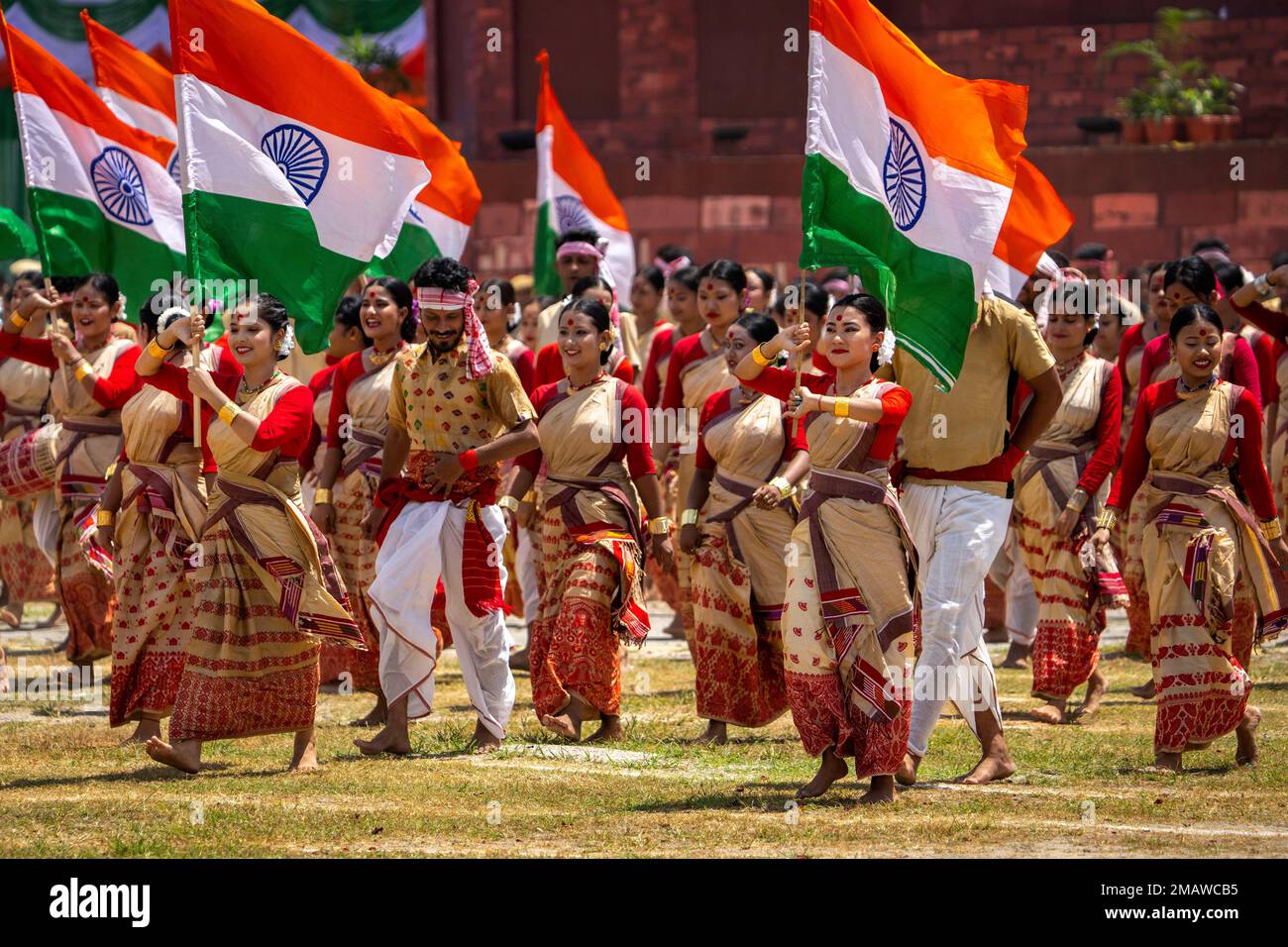 Assamese girls and boys in traditional attire carry Indian flags as ...