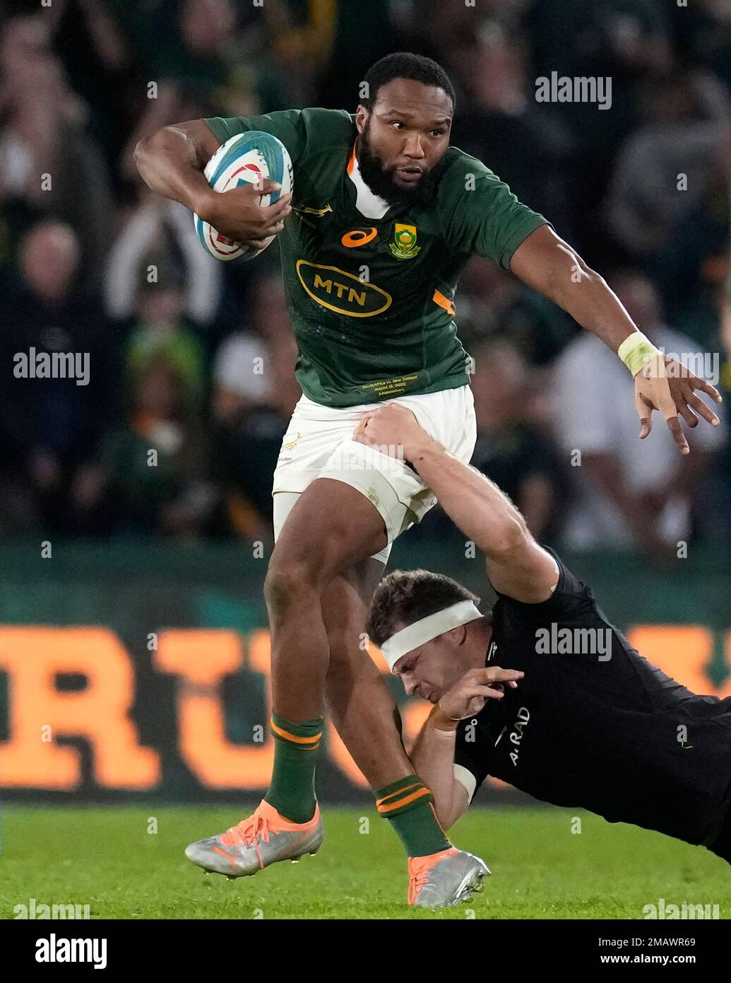 South Africa's Lukhanyo Am, left, avoids a tackle from New Zealand's ...