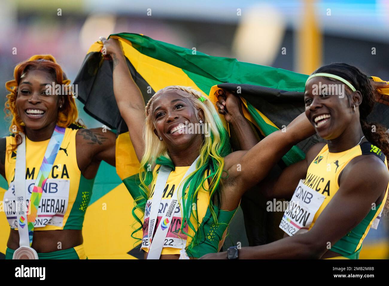 Shelly-Ann Fraser-Pryce, of Jamaica, center, reacts after winning Gold in the final in the women ...