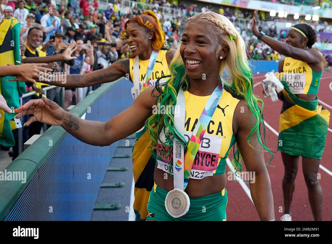 Gold medalist Shelly-Ann Fraser-Pryce, of Jamaica, center, greets fans with silver medalist ...
