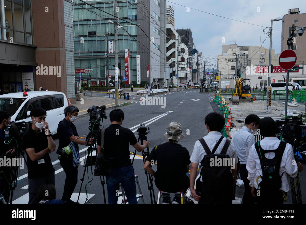 Members of the media report from the scene, center back, where former ...