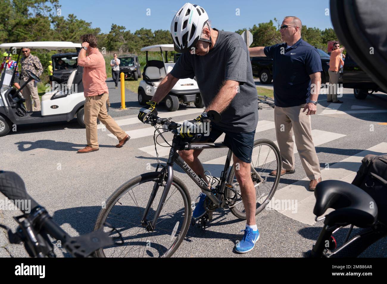 President Joe Biden gets back on his bike after he fell when he tried ...