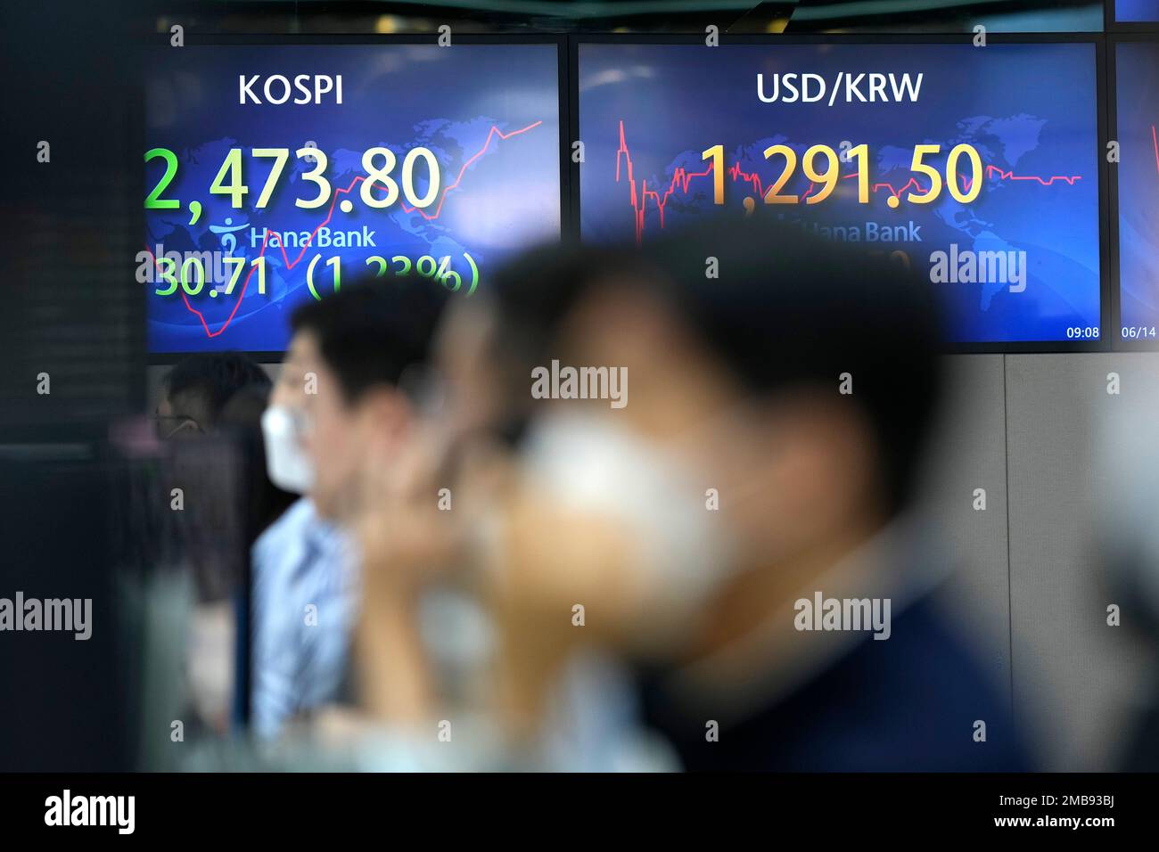 Currency traders watch computer monitors near screens showing the Korea ...