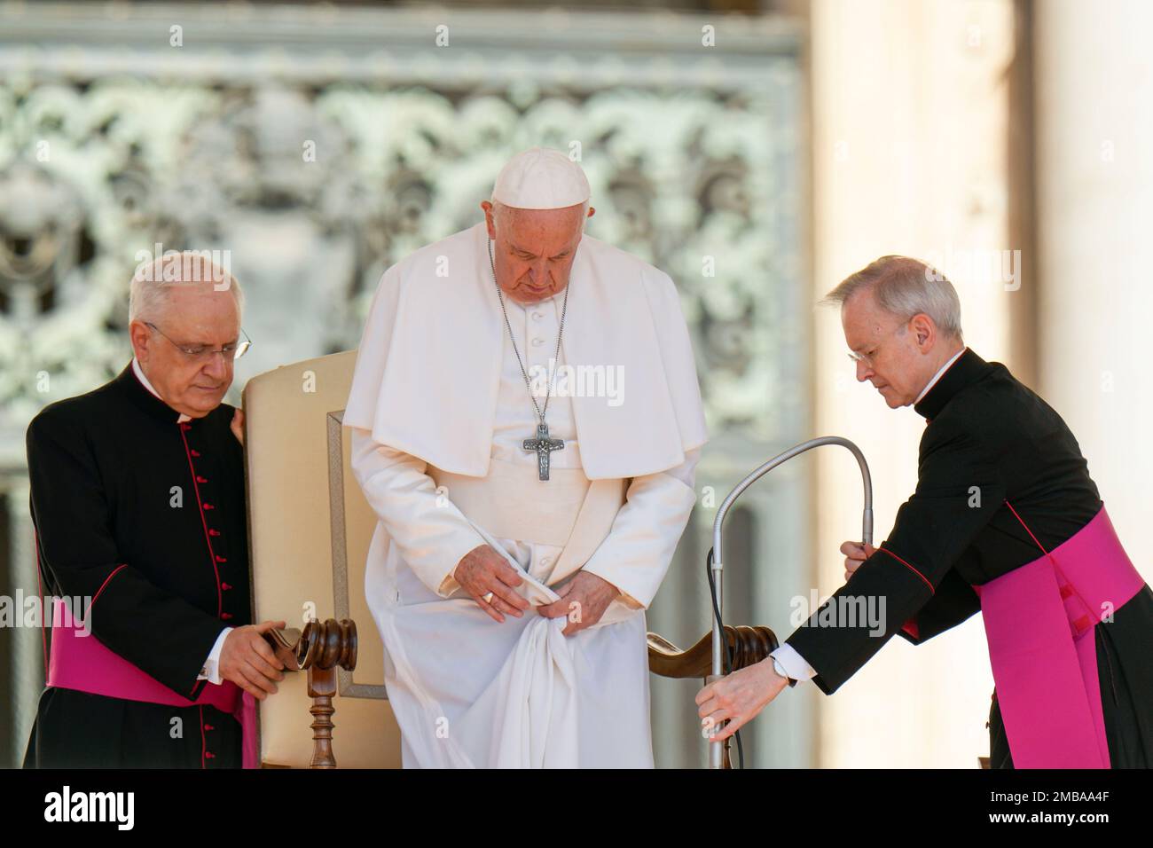 Pope Francis, helped by his aides, Monsignor Leonardo Sapienza, left ...