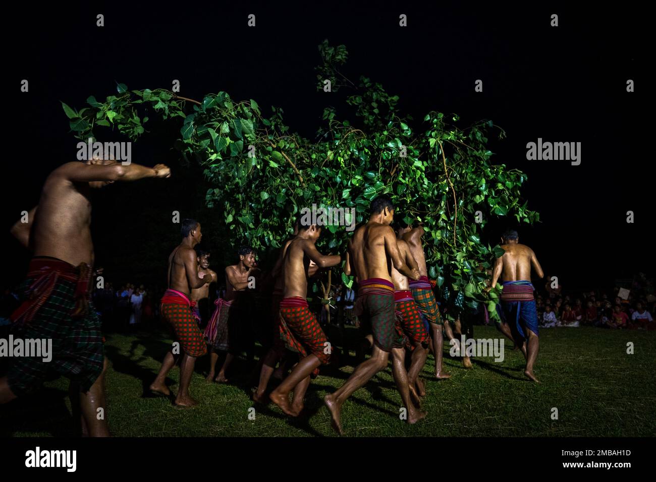 Indian Rabha tribal Hindu priests walk around tree branches as they ...